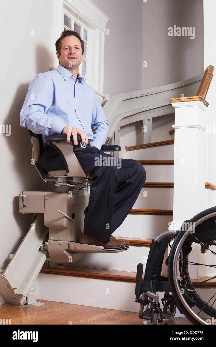 Man with spinal cord injury going up in his motorized stair lift Stock ...
