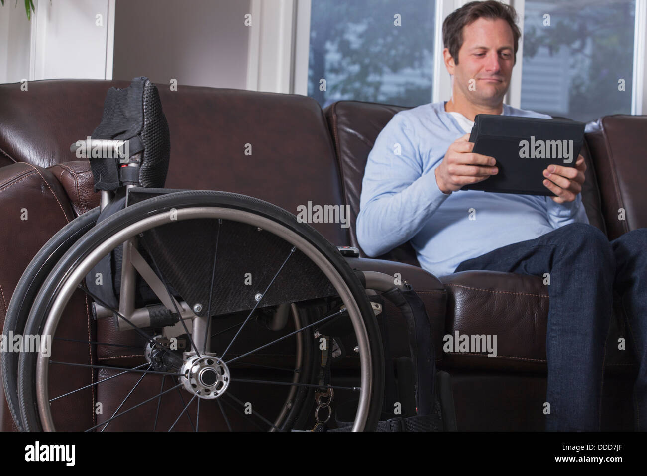 Man with spinal cord injury reading a tablet Stock Photo - Alamy