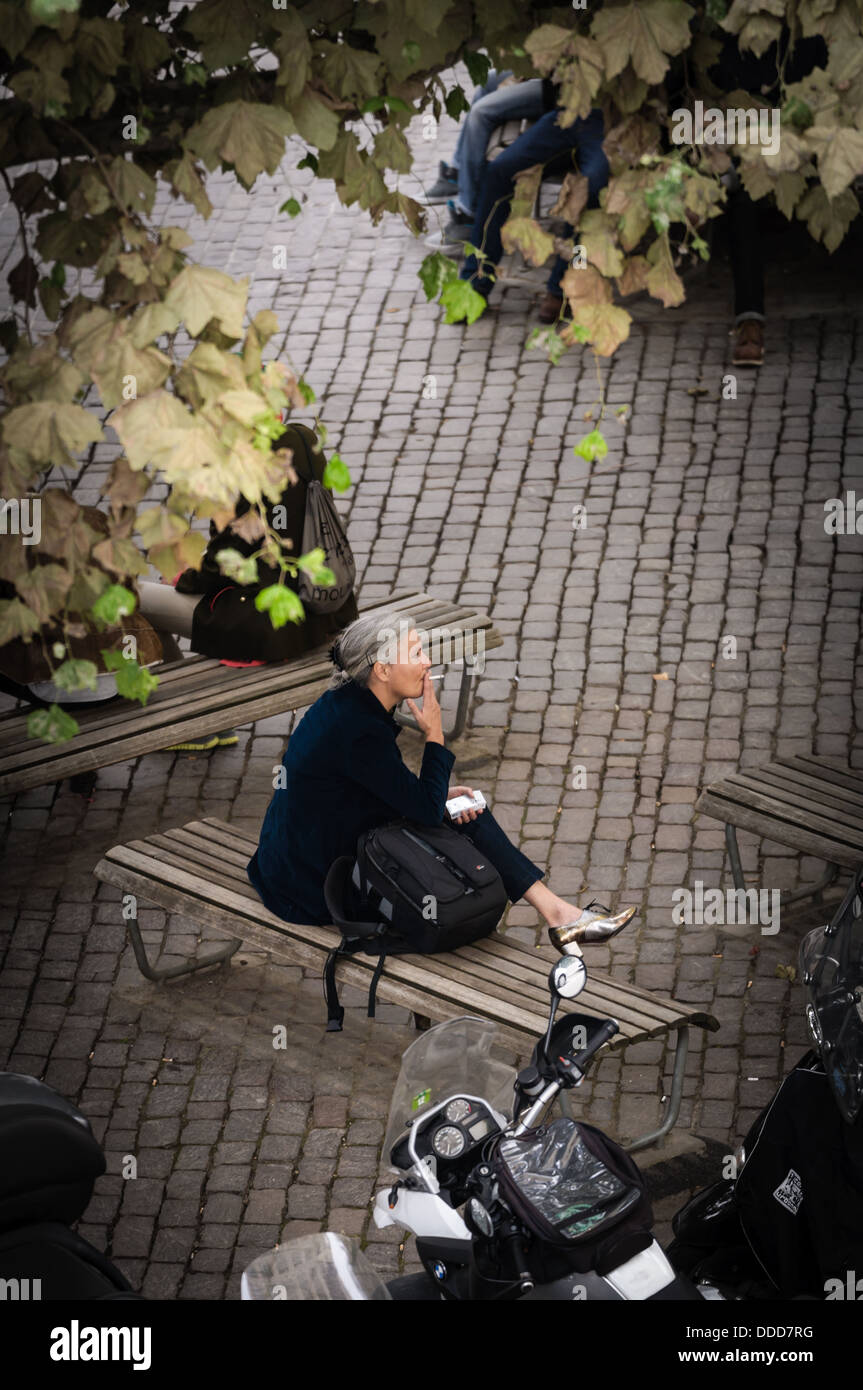 Woman smoking on a bench Stock Photo - Alamy