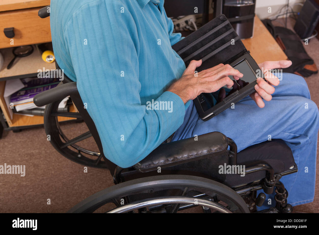Man with Friedreich's Ataxia in wheelchair using a tablet with deformed ...