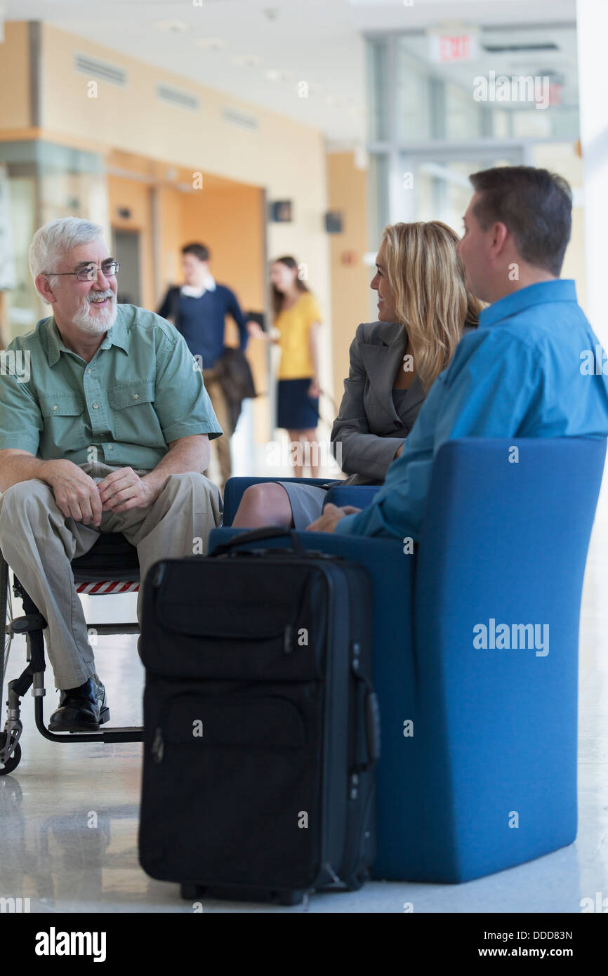 Passengers talking o each other in an airport lounge Stock Photo - Alamy