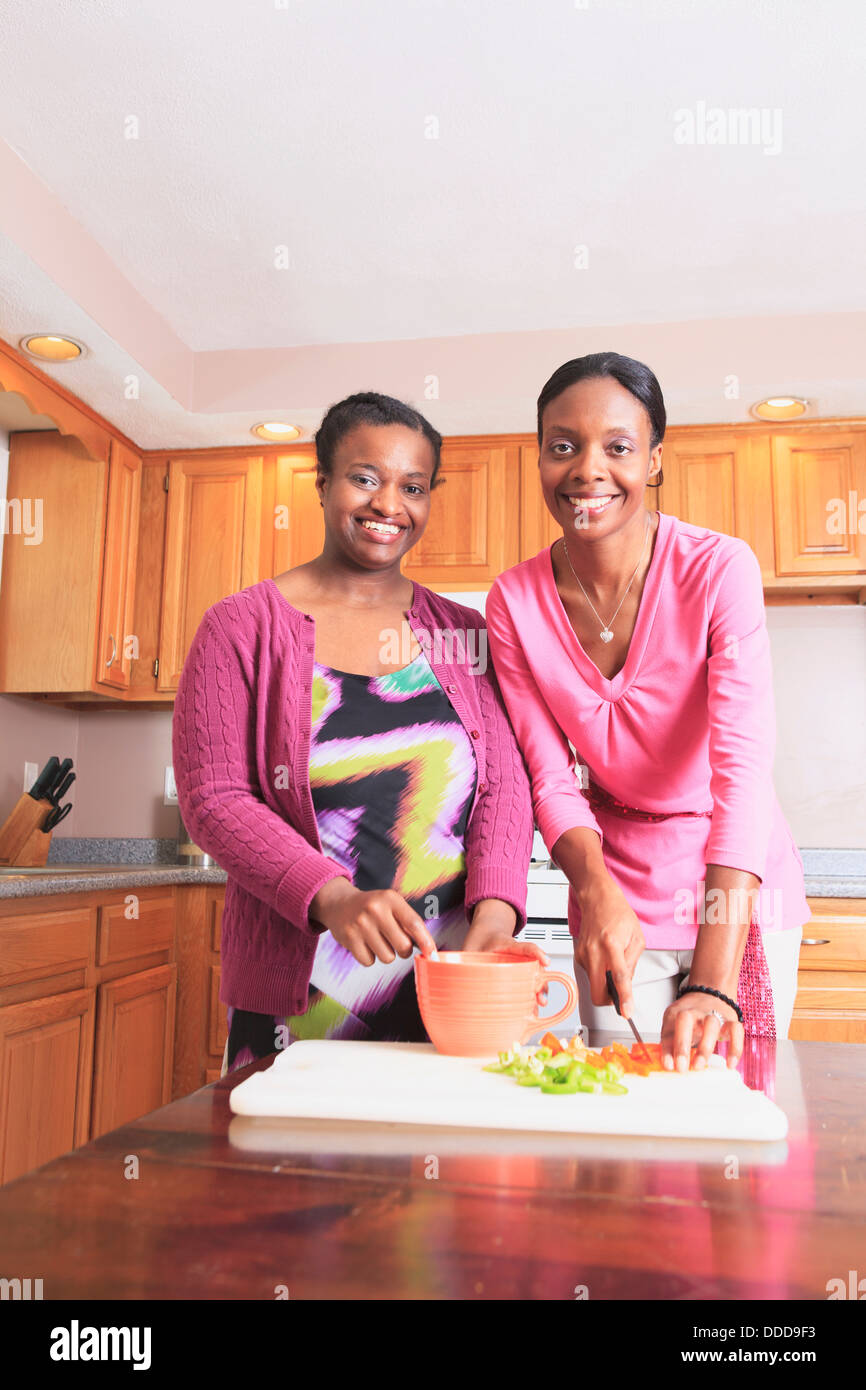 Two sisters cooking in the kitchen, one with learning disability Stock ...