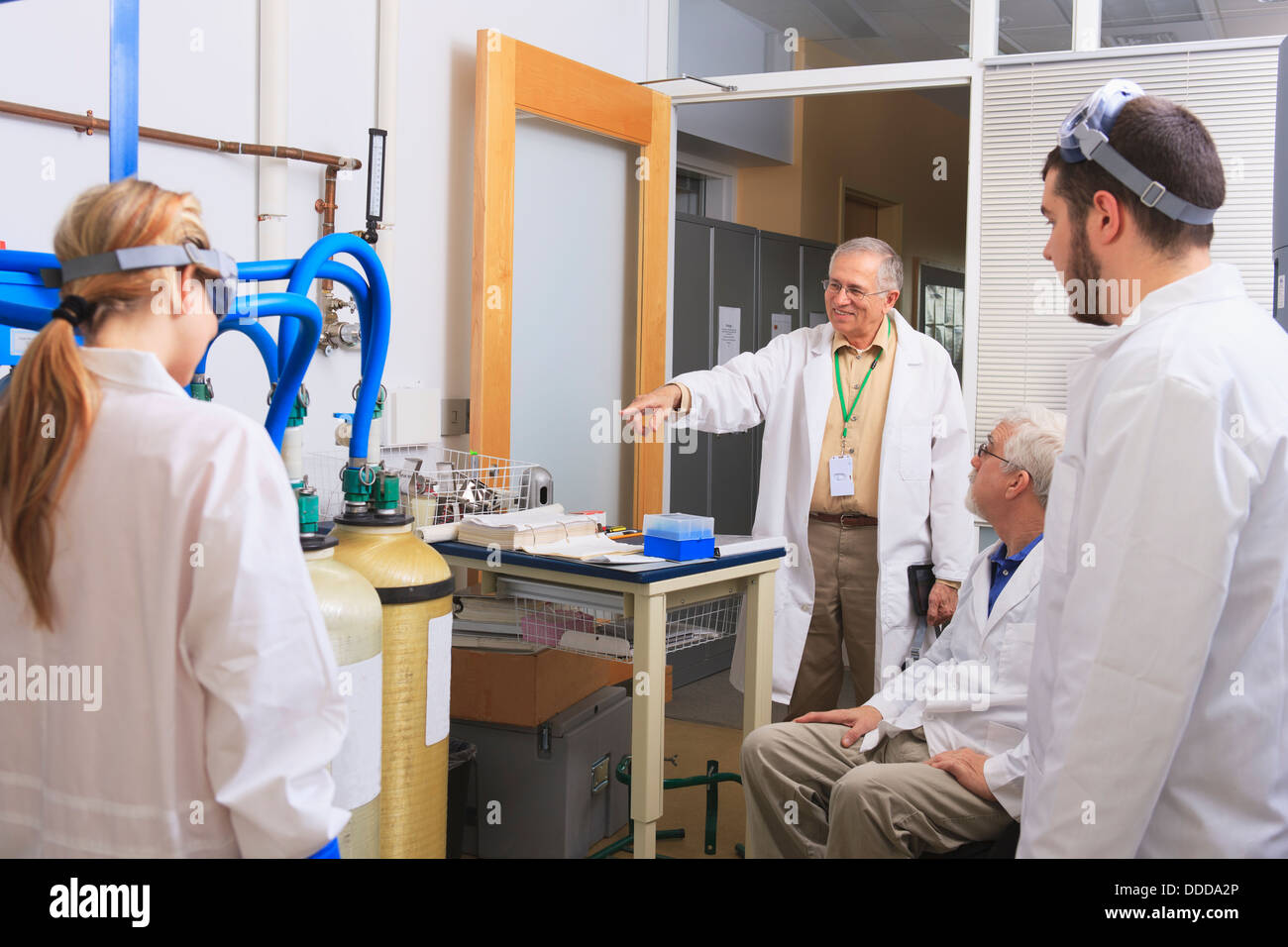 Professors talking to engineering students discussing water ...