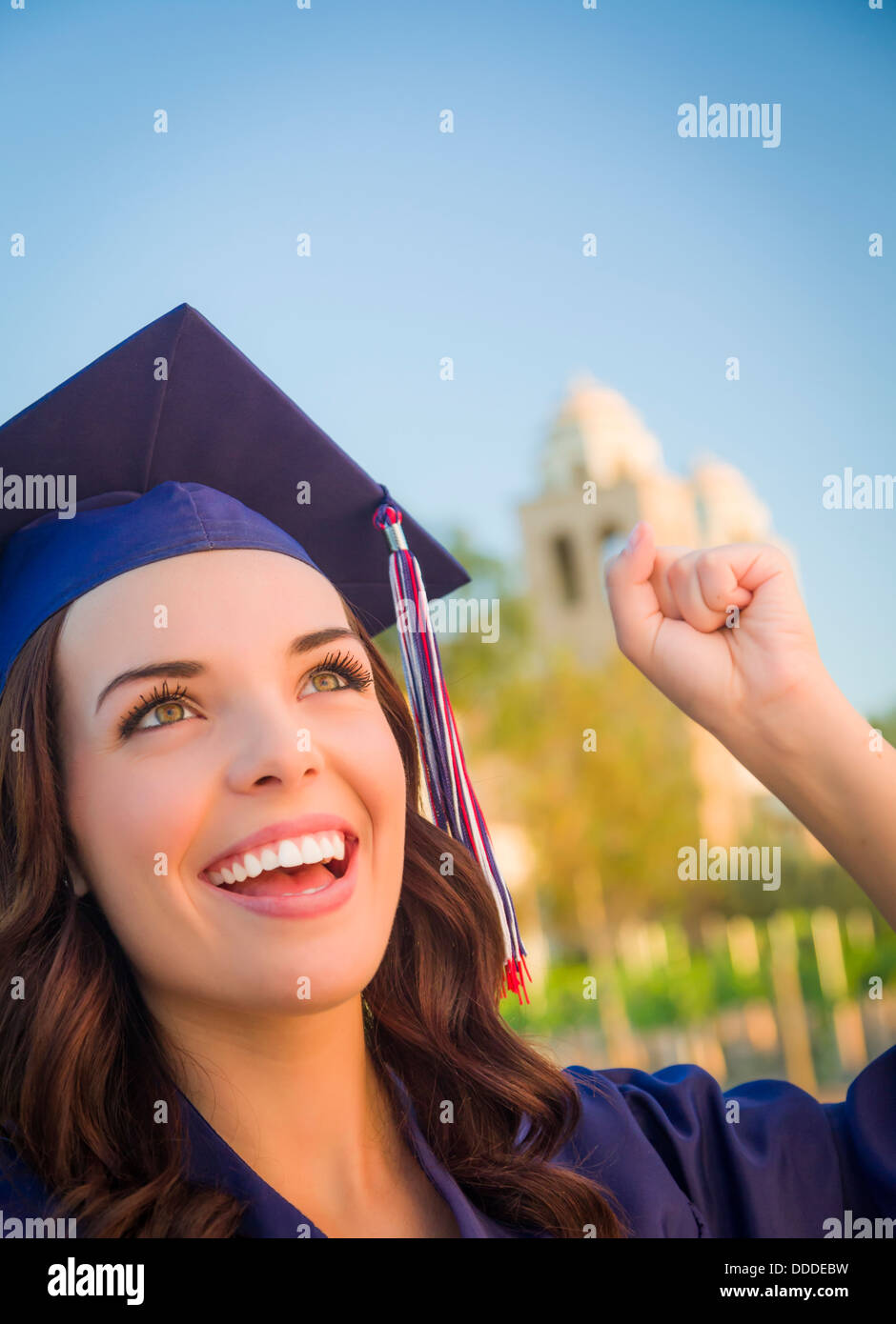 Happy Graduating Mixed Race Woman In Cap and Gown Celebrating on Campus ...