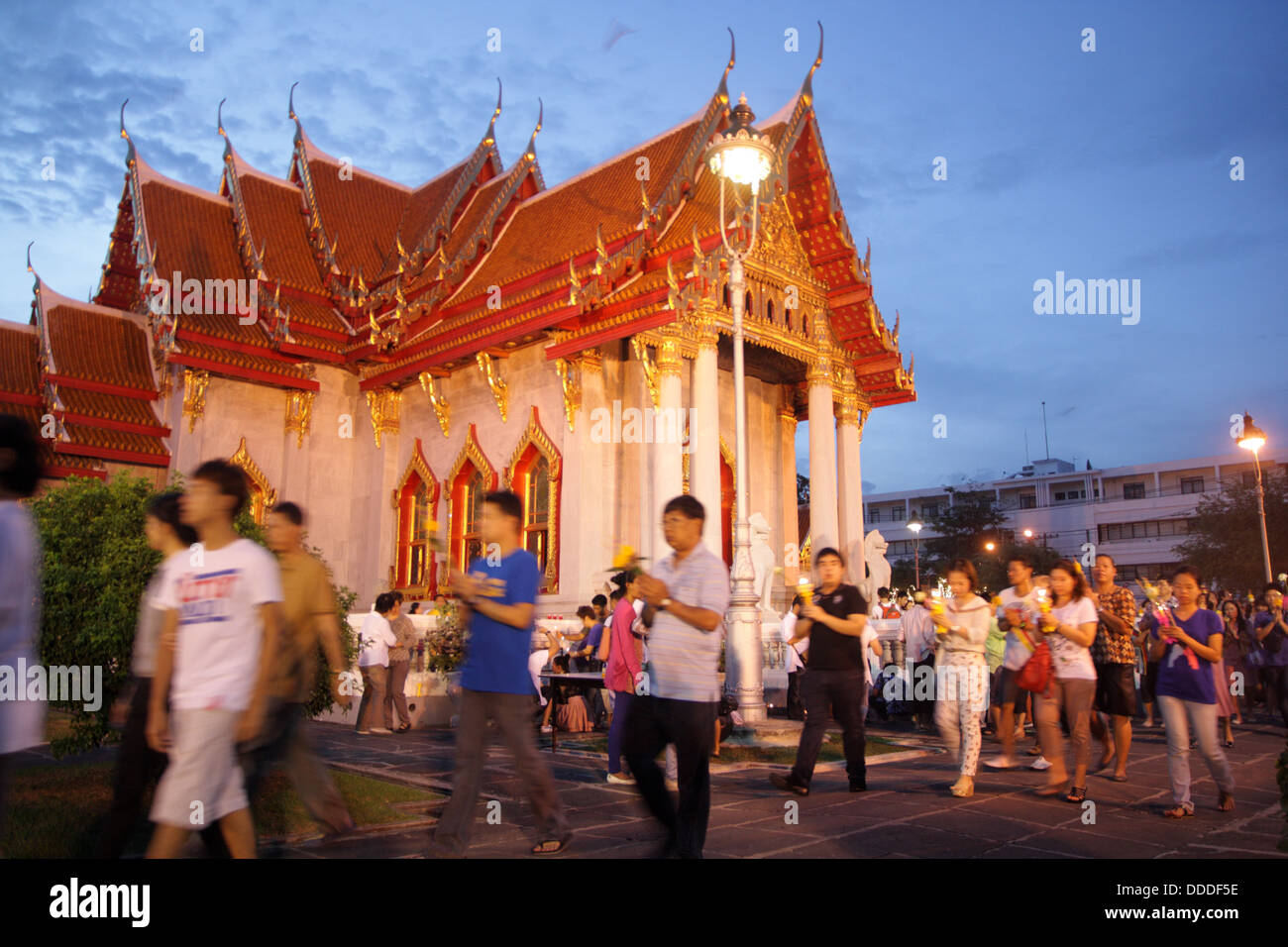 Worshipers holding candles make a circumambulation of Wat ...