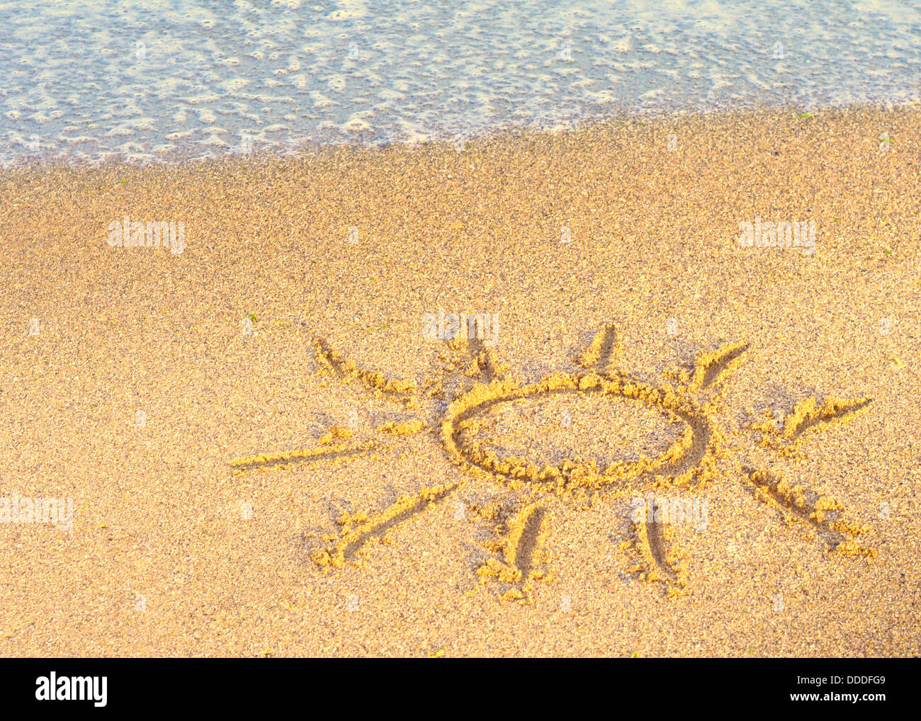 Drawing of the sun on sand with sea wave Stock Photo - Alamy
