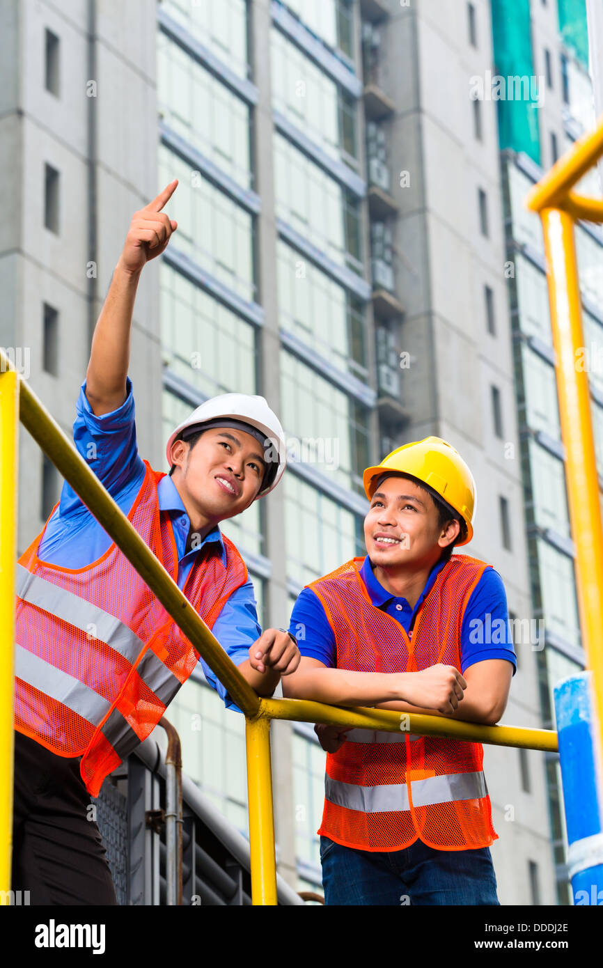 Chinese architect and supervisor point on building site into the ...
