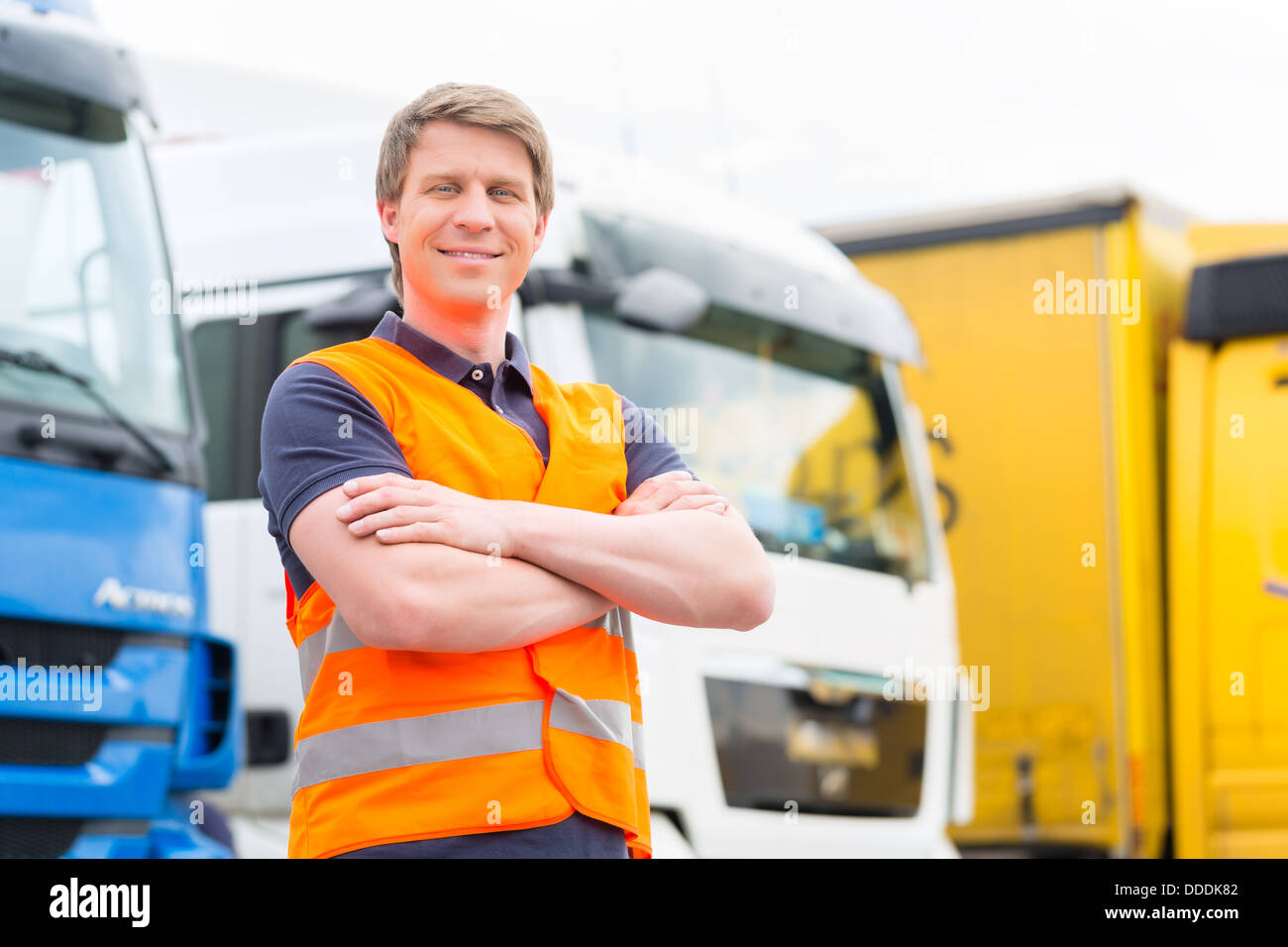 Logistics - proud driver or forwarder in front of trucks and trailers ...