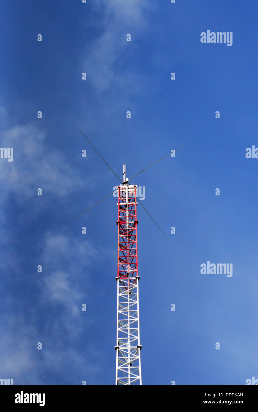Red and white antenna against partly cloudy blue sky Stock Photo - Alamy