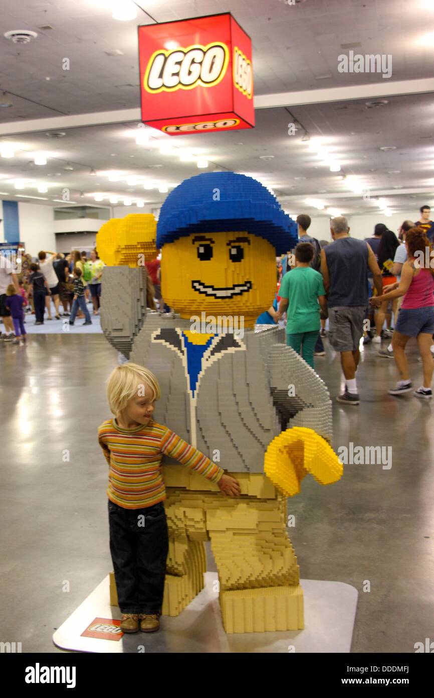 A young blonde girl poses for a photo with a LEGO sculpture at a LEGO ...