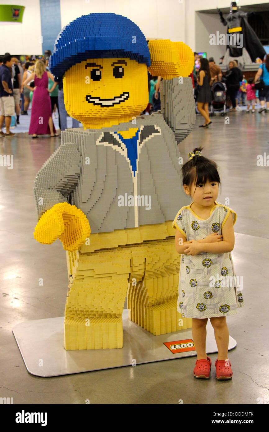 A young Asian girl poses for a photo by a LEGO sculpture at a LEGO ...