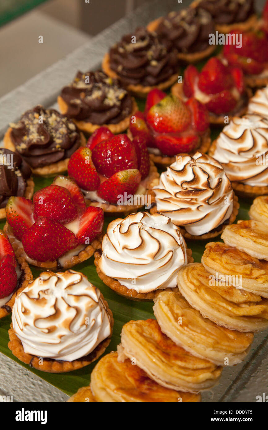 Groups of sweets placed in rows on rectangular glass plate on dining ...