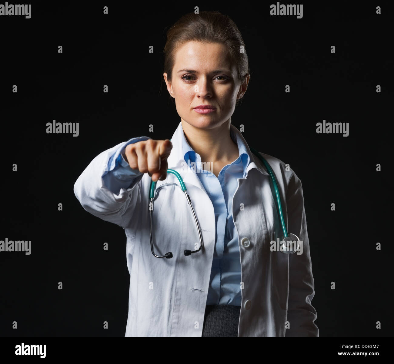Doctor woman pointing in camera isolated on black Stock Photo - Alamy