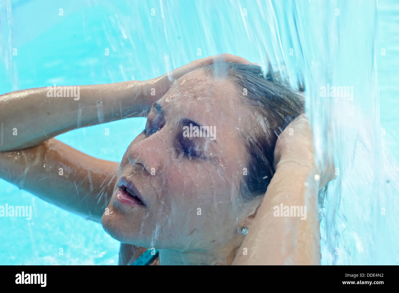 A woman rinses her hair in a waterfall Stock Photo - Alamy