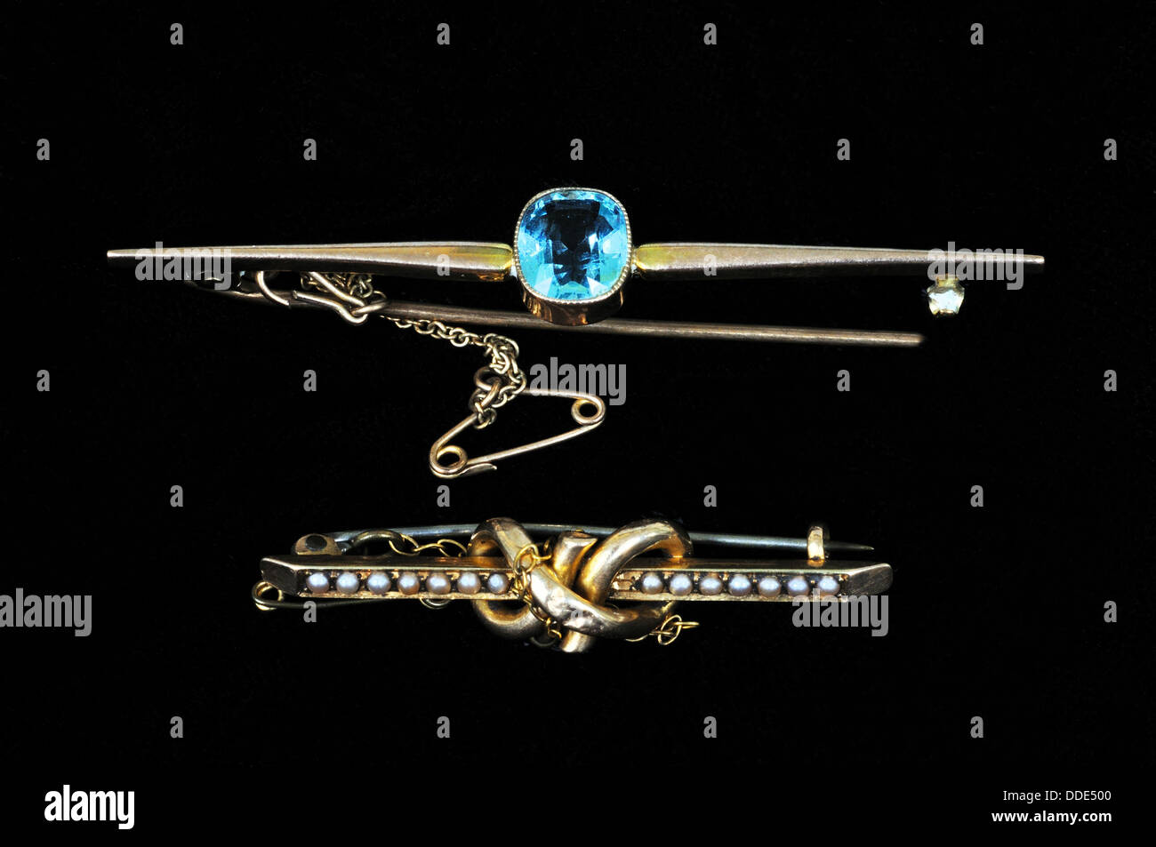 Two antique gold scarf pins against a black background Stock Photo - Alamy