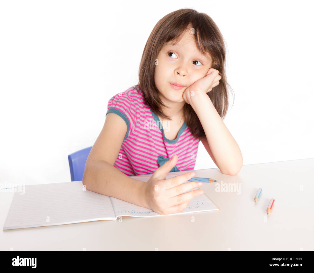 Child at desk with pencils and notebook Stock Photo - Alamy