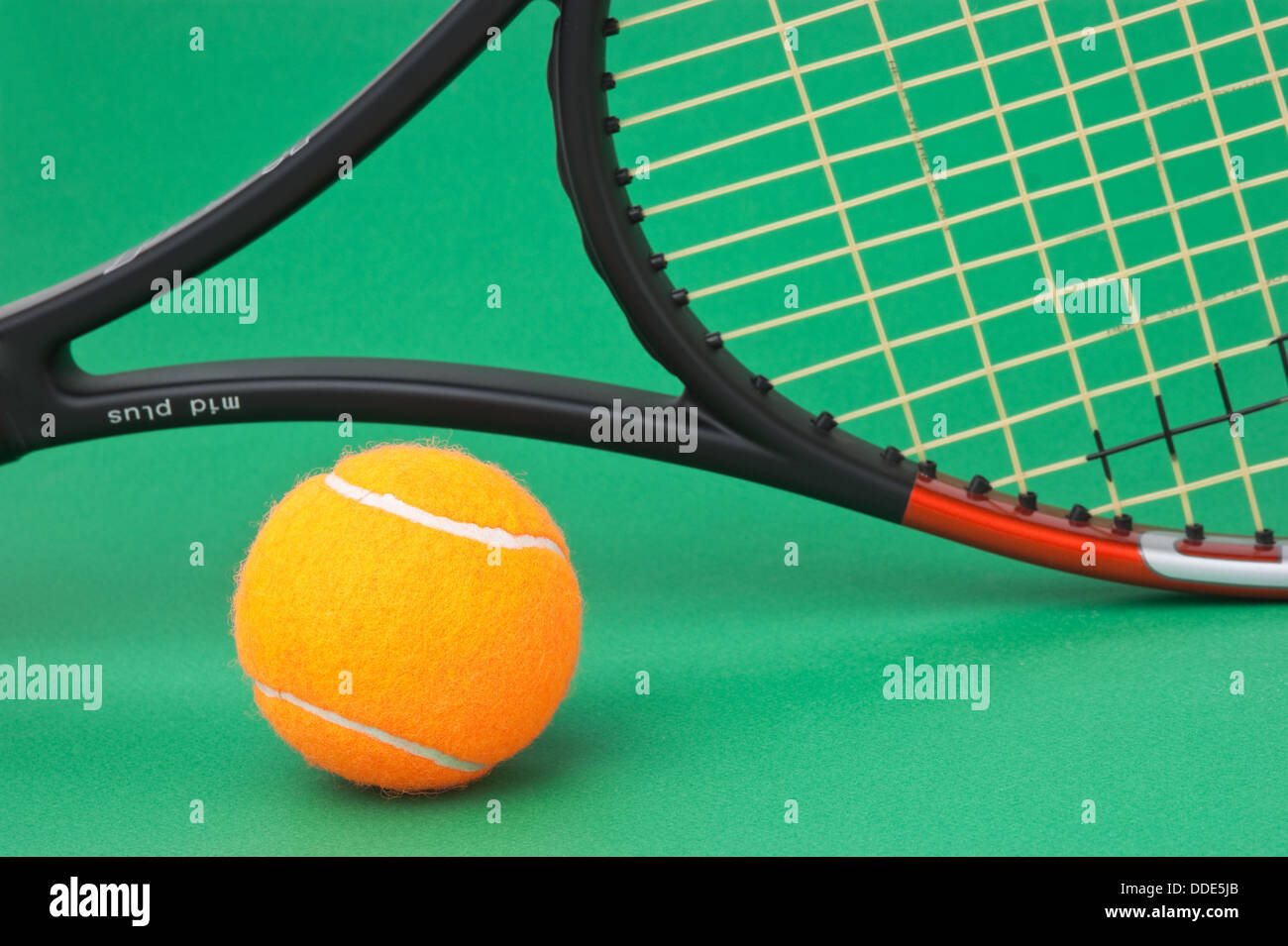 tennis racket and ball on a green background Stock Photo - Alamy