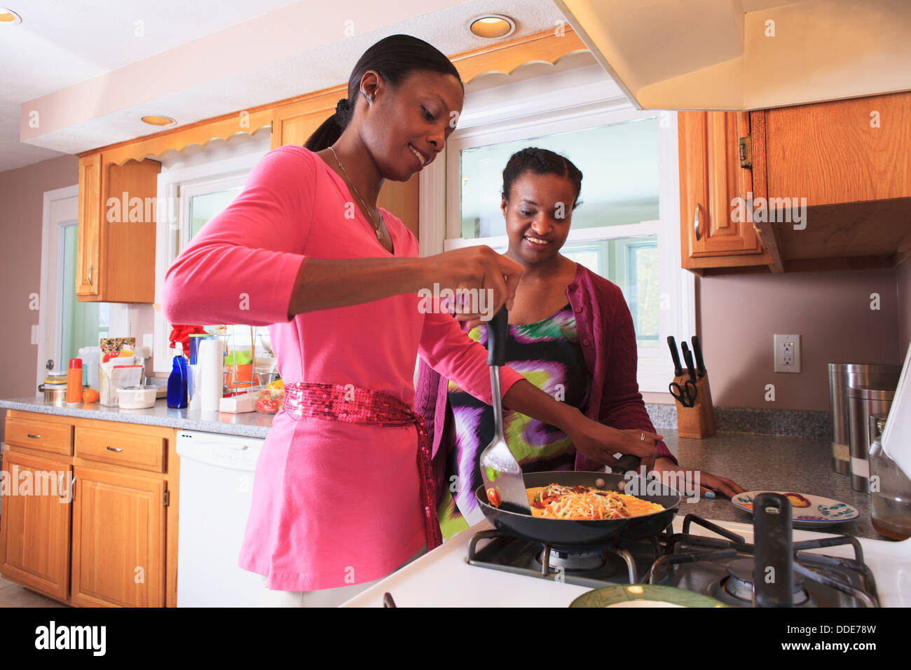 Two sisters cooking in the kitchen, one with learning disability Stock ...