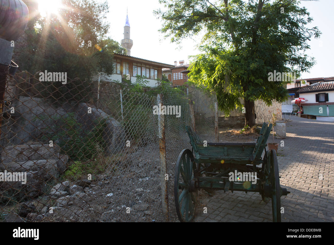 An old wooden cart in a street in Side, Turkey, with the minaret of the ...