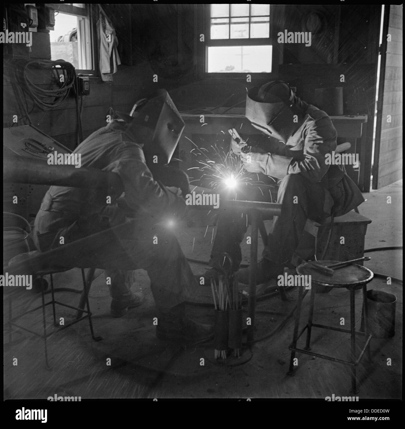 A photograph of welders working in the machine shop at the Poston War ...