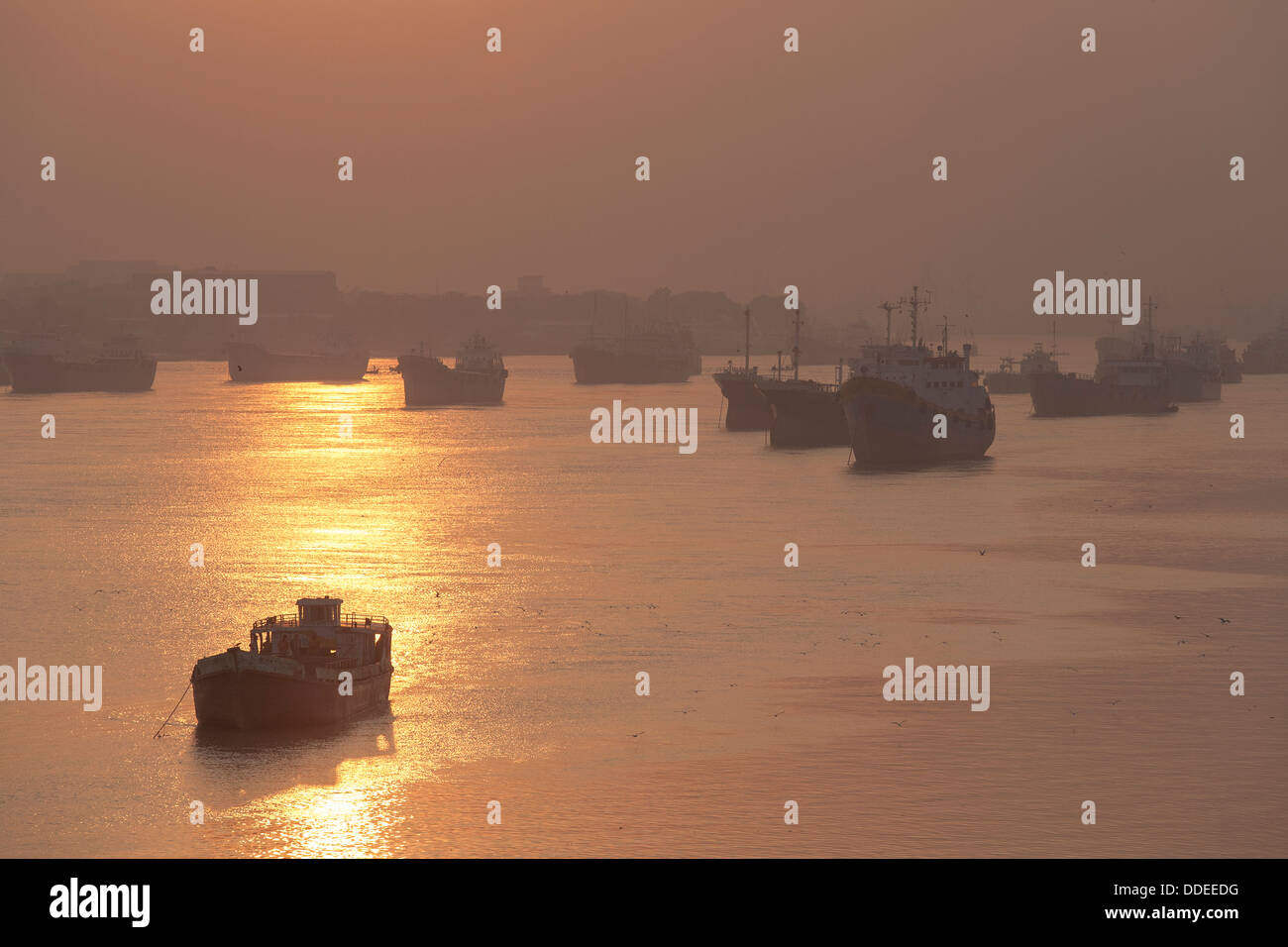 Cargo ships anchored at dusk in the Port of Chittagong on the ...