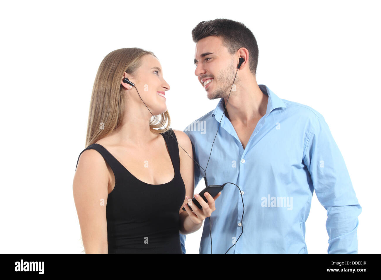 Attractive couple sharing music with a headphones isolated on a white ...