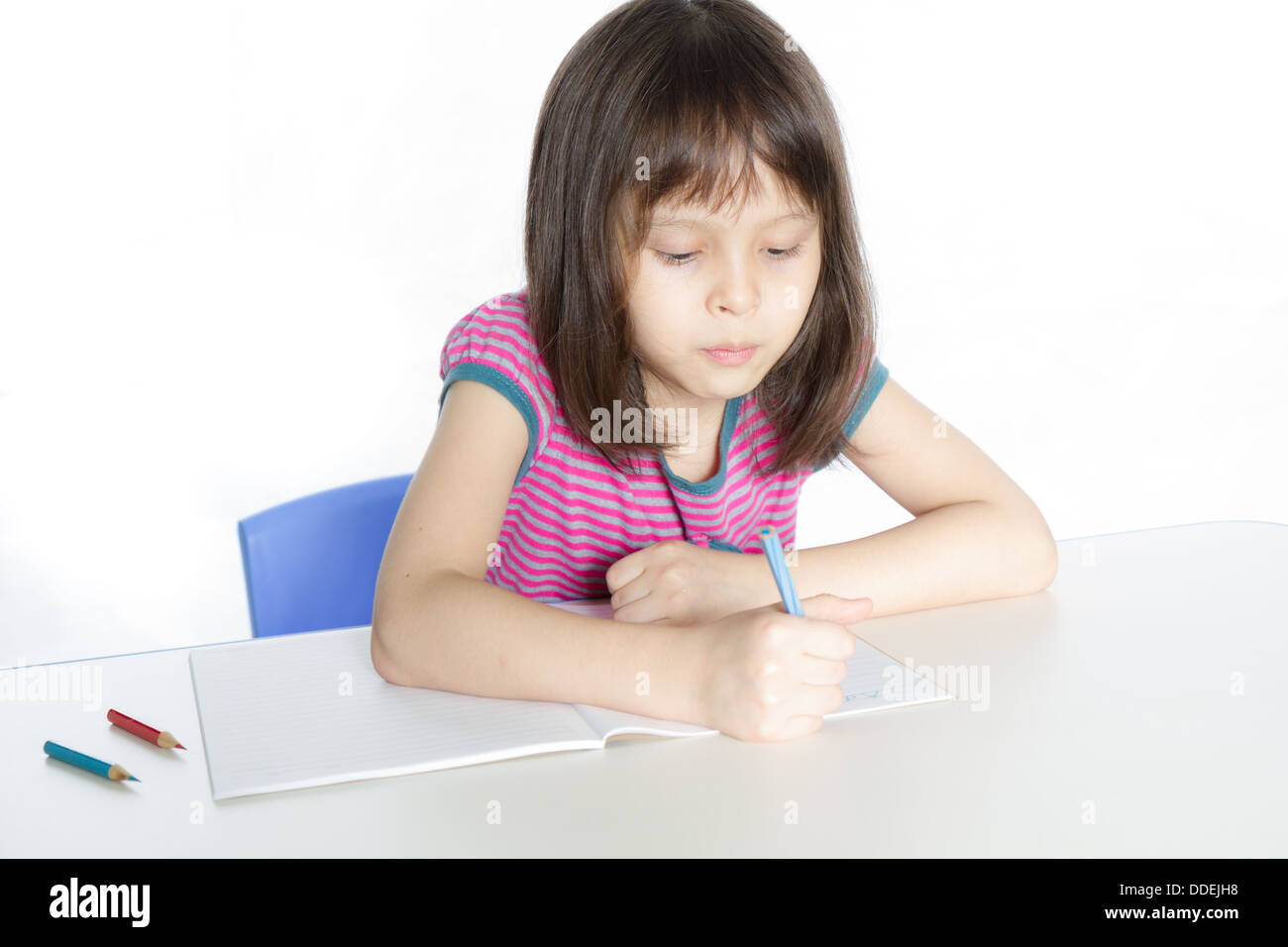 Child at desk with pencils and notebook Stock Photo - Alamy