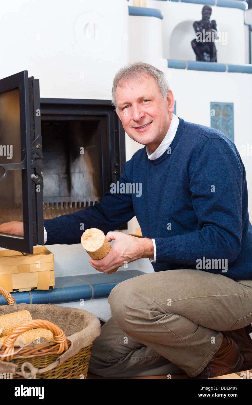 Quality of life - older man or pensioner stoke the fire in his ...