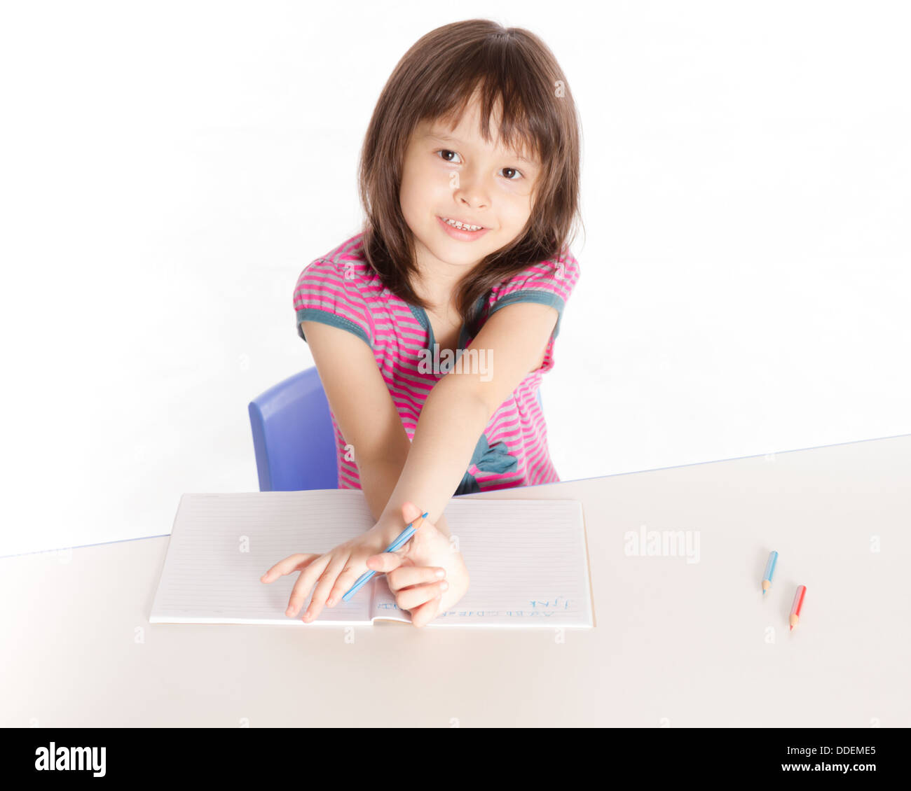 Child at desk with pencils and notebook Stock Photo - Alamy