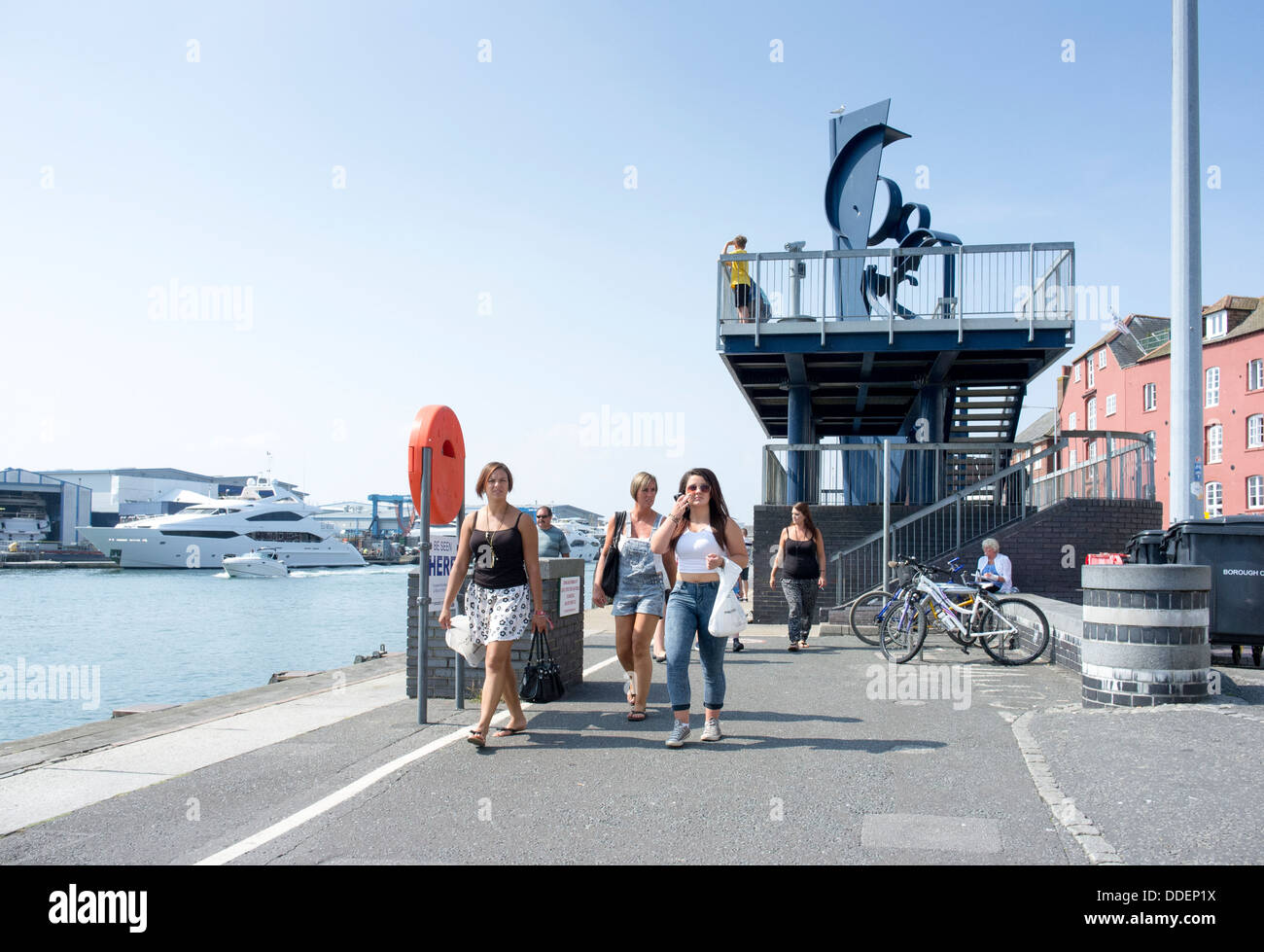 People girls women walking along Poole Quay Dorset UK with viewing ...