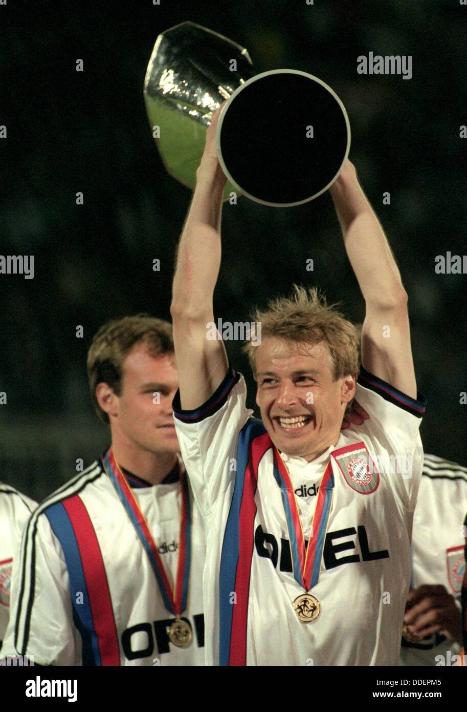 Striker of Bayern Munich Jürgen Klinsmann holds up the UEFA cup in ...