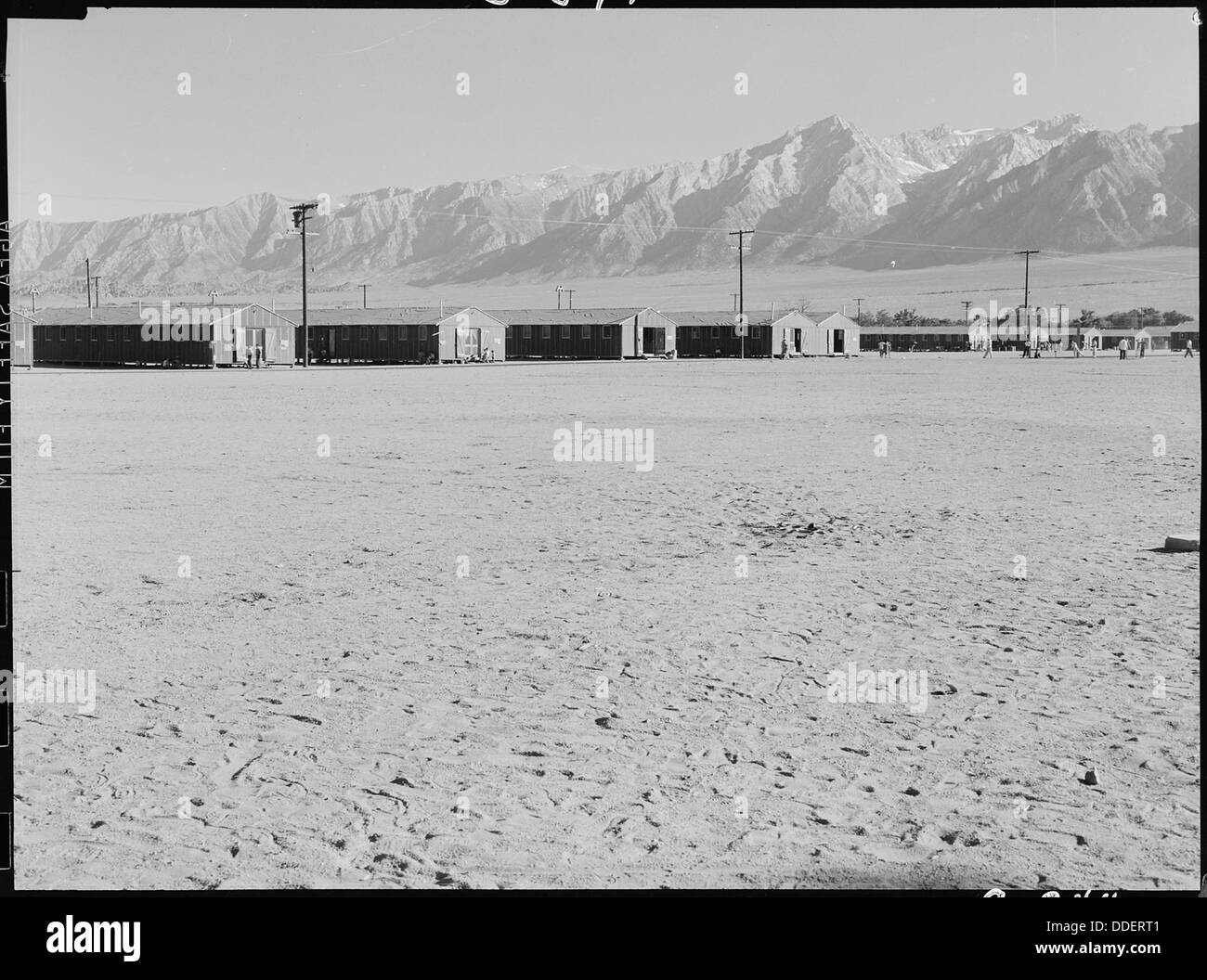 The image depicts a view of the barracks at the Manzanar Relocation ...