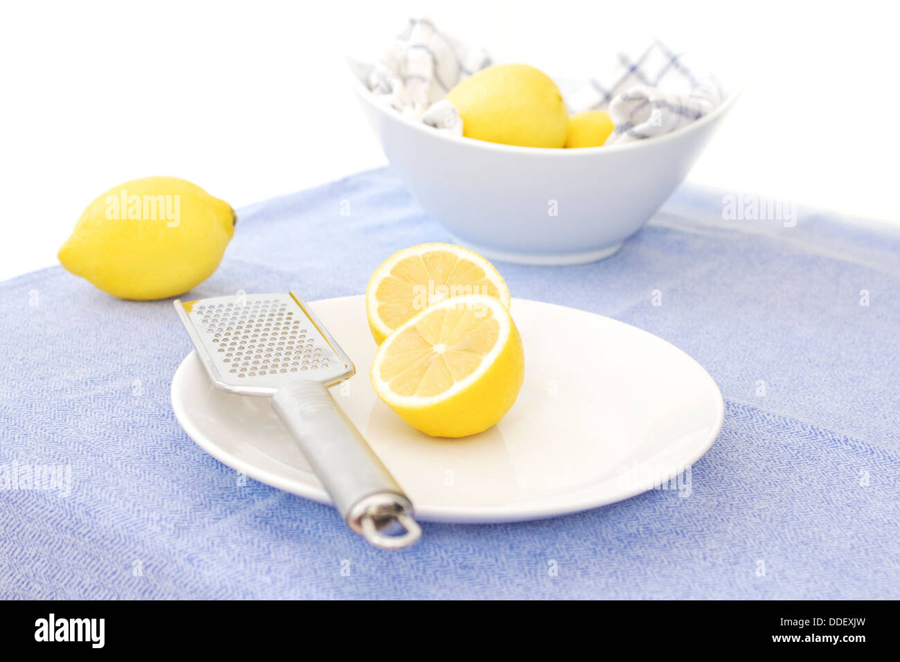 Unwaxed lemons on a plate with a lemon zester, and a bowl of lemons in ...