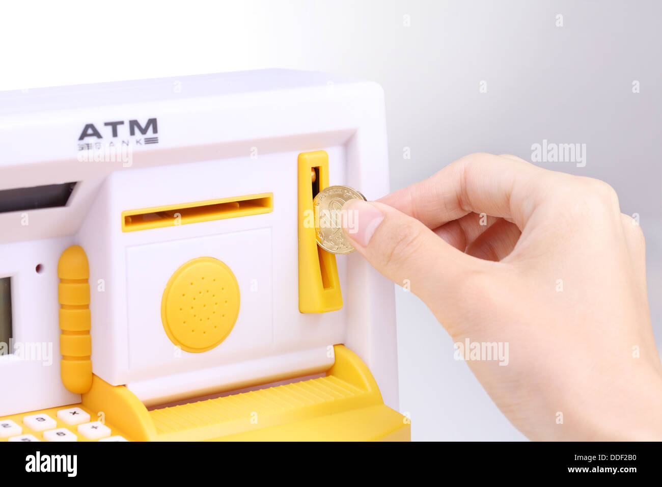 Hand holding the coins into ATM Stock Photo - Alamy