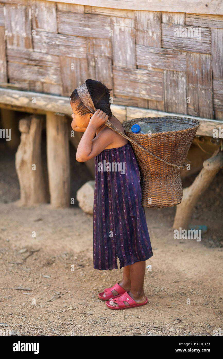 A young tribal Bom girl carries a basket on a headstrap in the villages ...