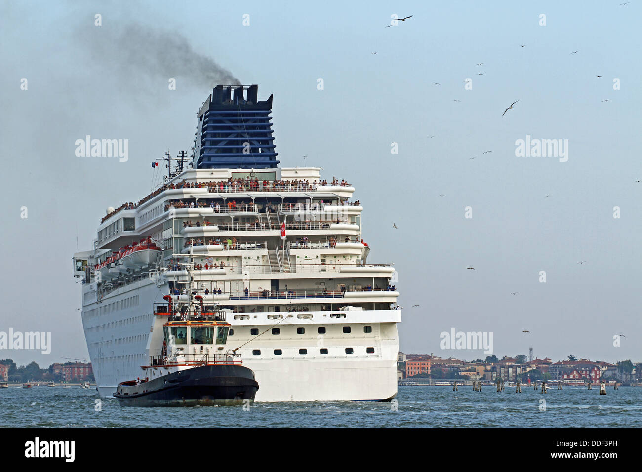 Powerful tugboat while accurately manoeuvre the large cruise ship out ...