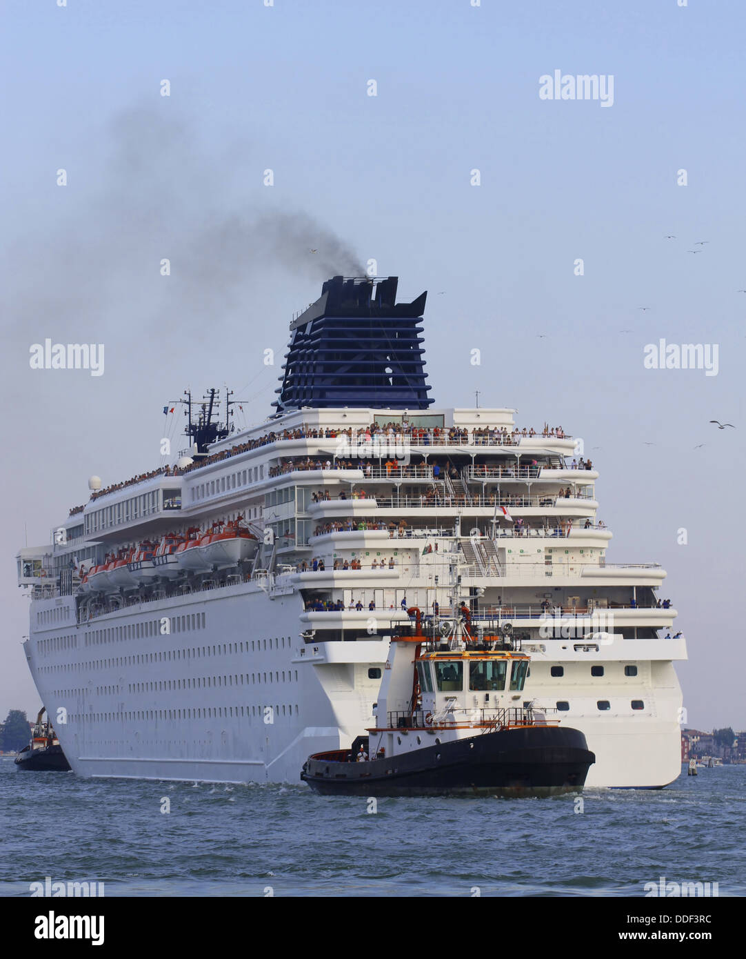 Powerful tugboat while accurately manoeuvre the large cruise ship out ...
