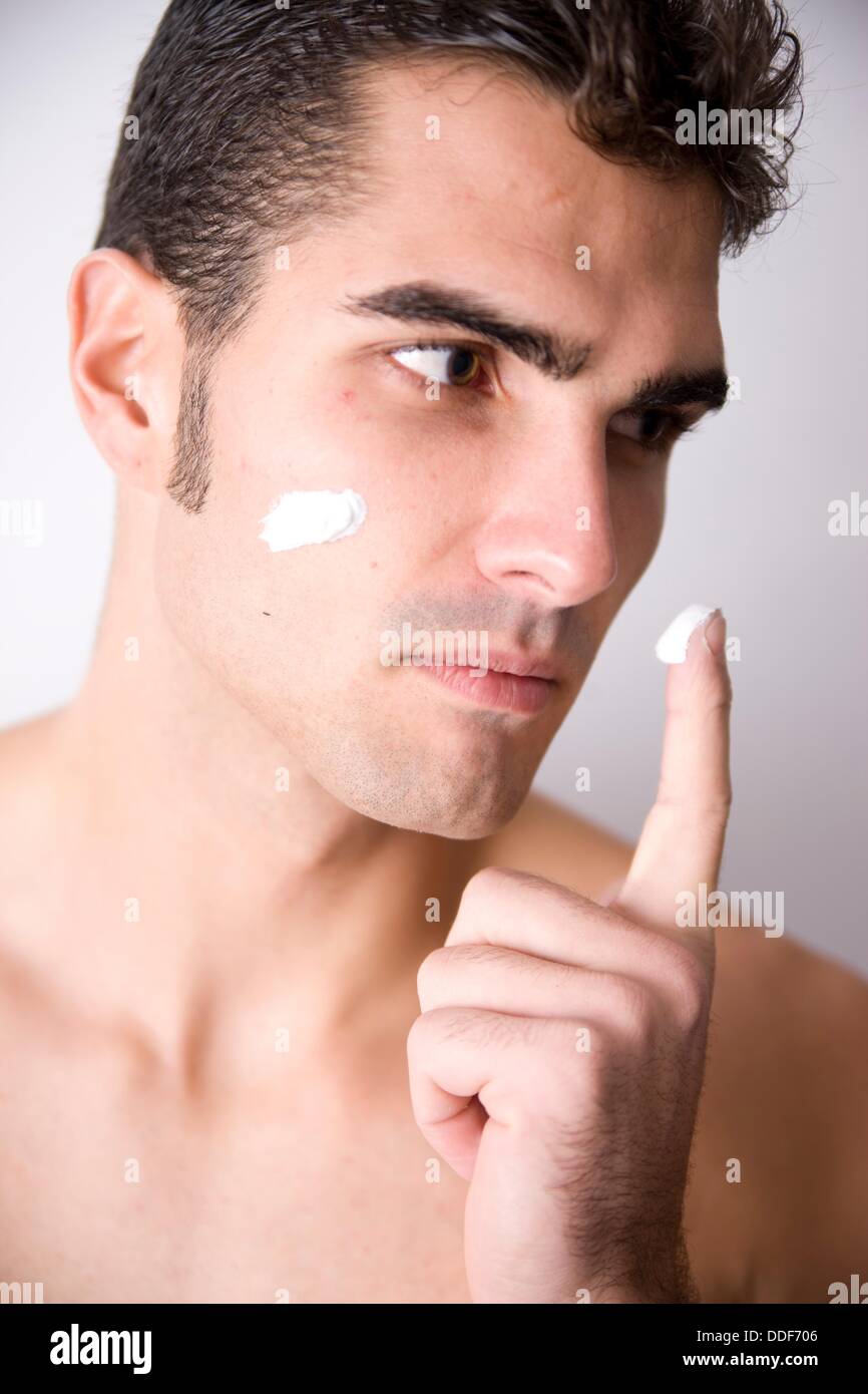 Young man applying facial cream Stock Photo - Alamy