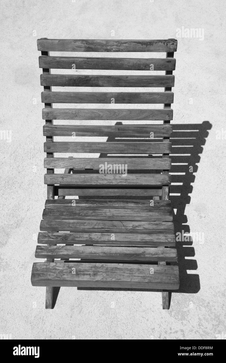 A grey scale image of a small wooden slatted chair Stock Photo - Alamy
