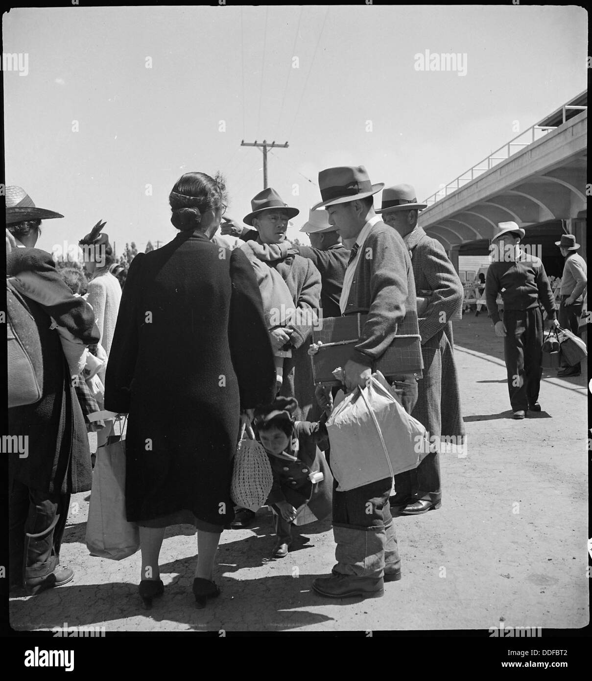 This photo shows families of Japanese ancestry arriving at an assembly ...