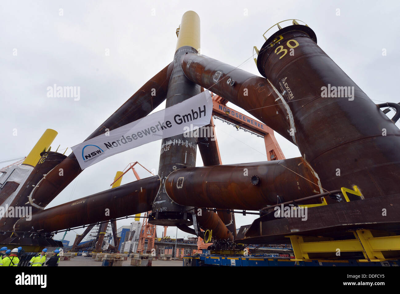 A tripod is loaded watched by employees on the shipyard grounds in ...