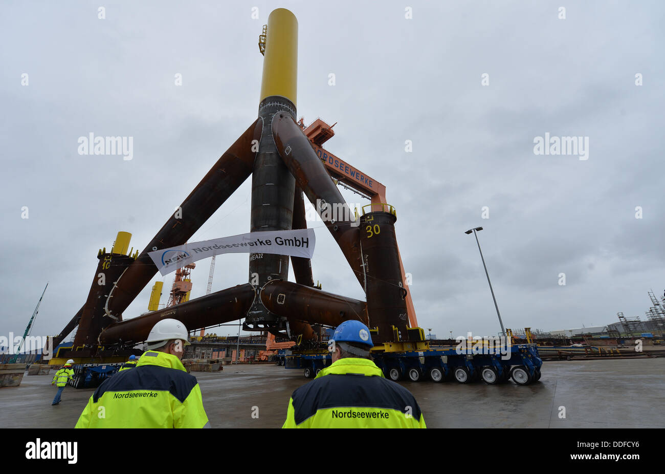 A tripod is loaded watched by employees on the shipyard grounds in ...