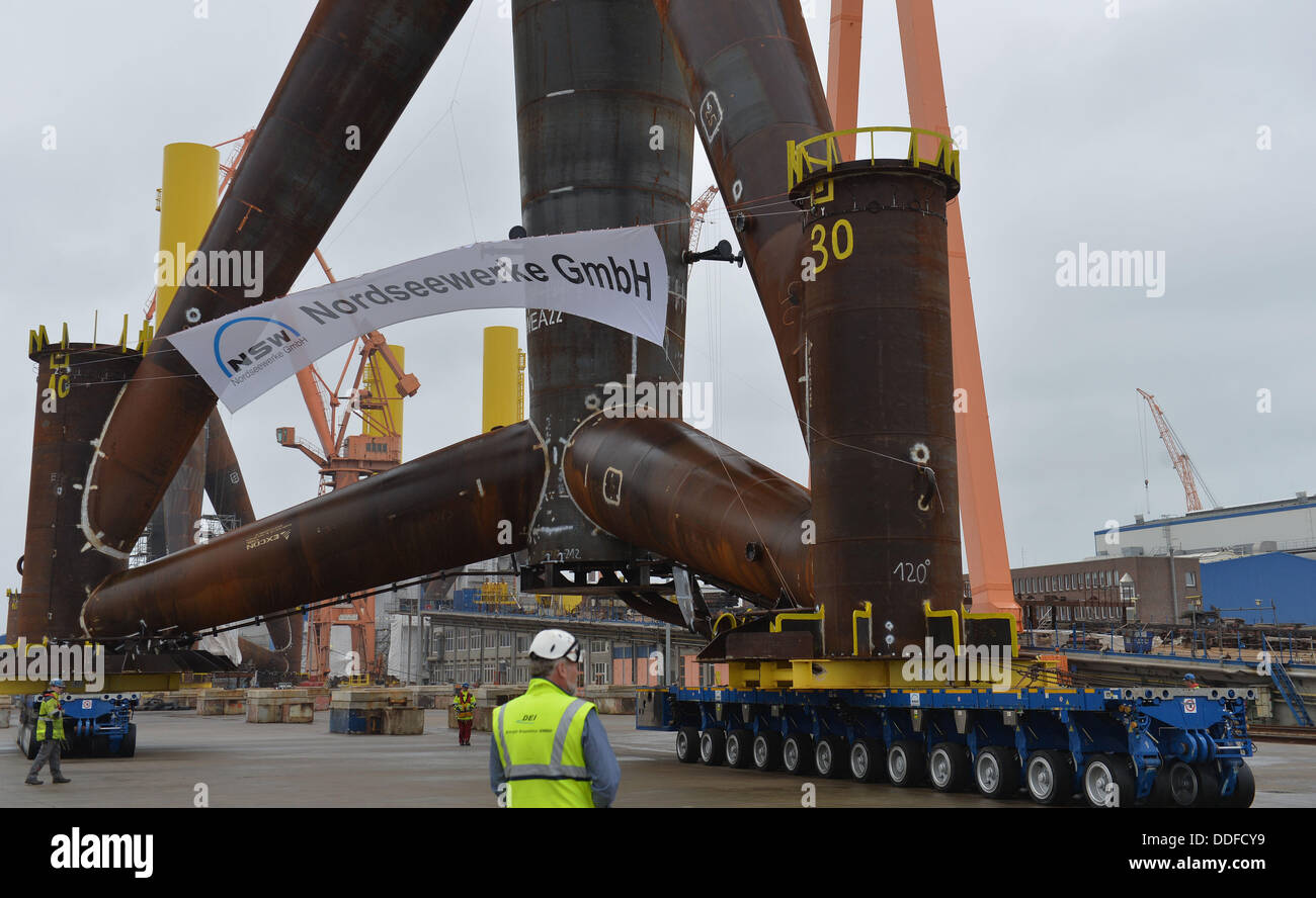 A tripod is loaded watched by employees on the shipyard grounds in ...