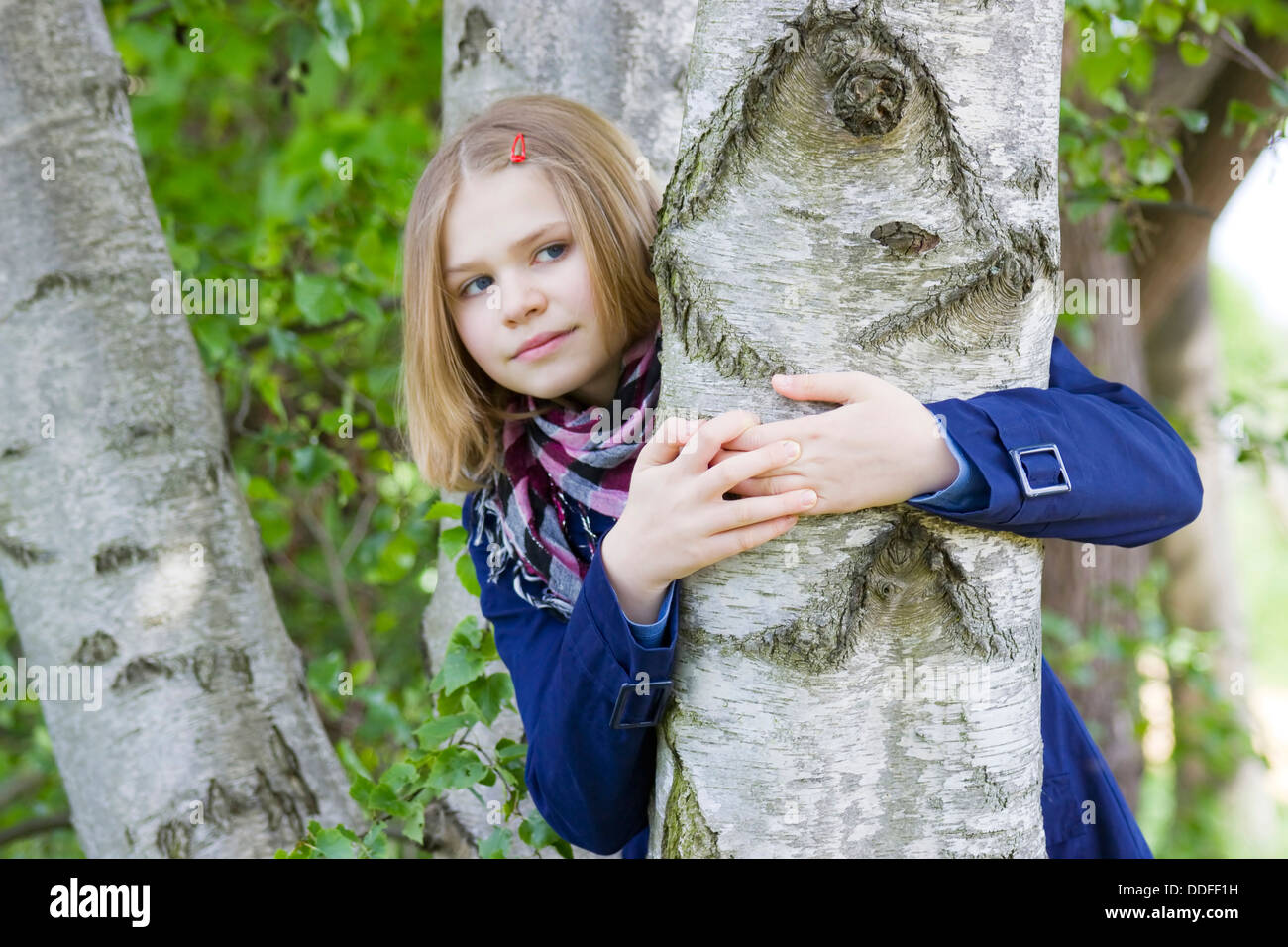 Girl hugging tree trunk and smiling Stock Photo - Alamy