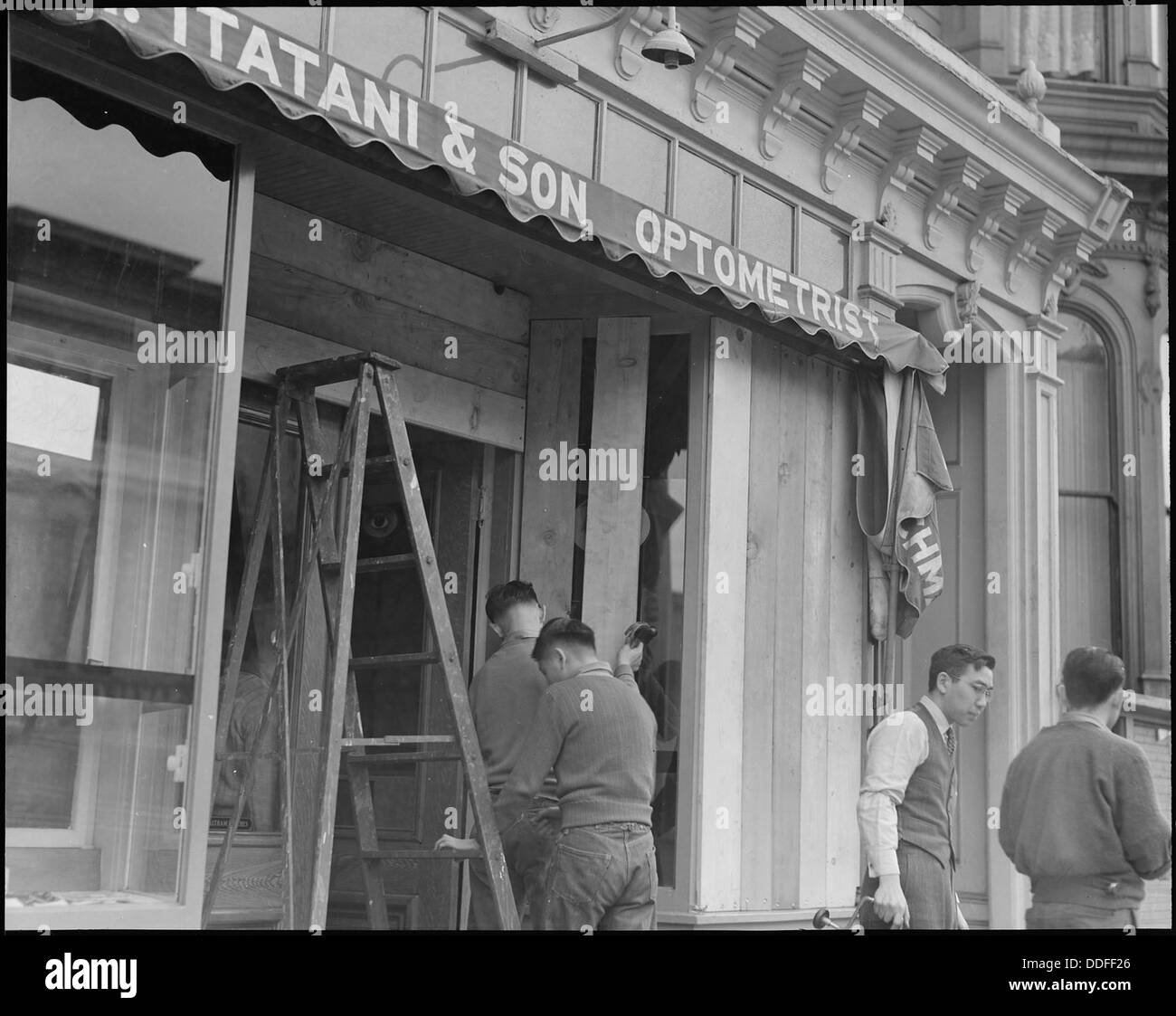 This photograph shows owners of Japanese ancestry boarding up their ...