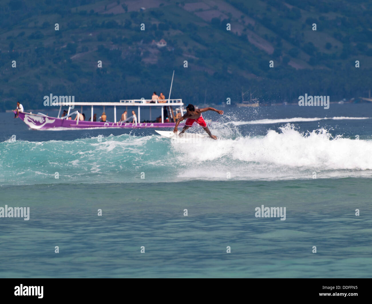 Sufer in Gili Trawangan sea with boat in background Stock Photo - Alamy