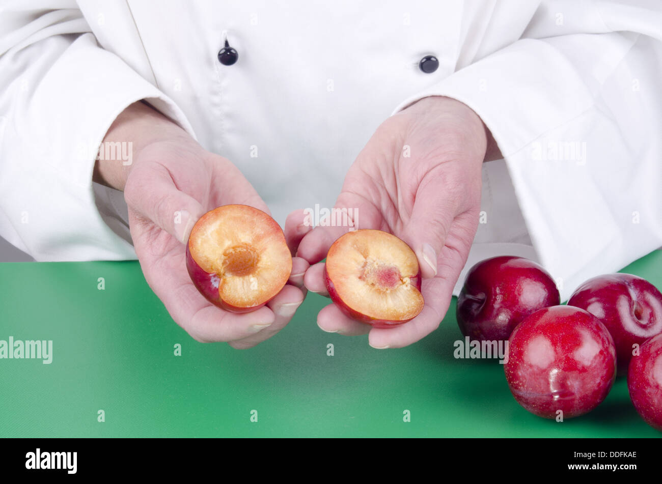 female chef with a divided plum Stock Photo - Alamy