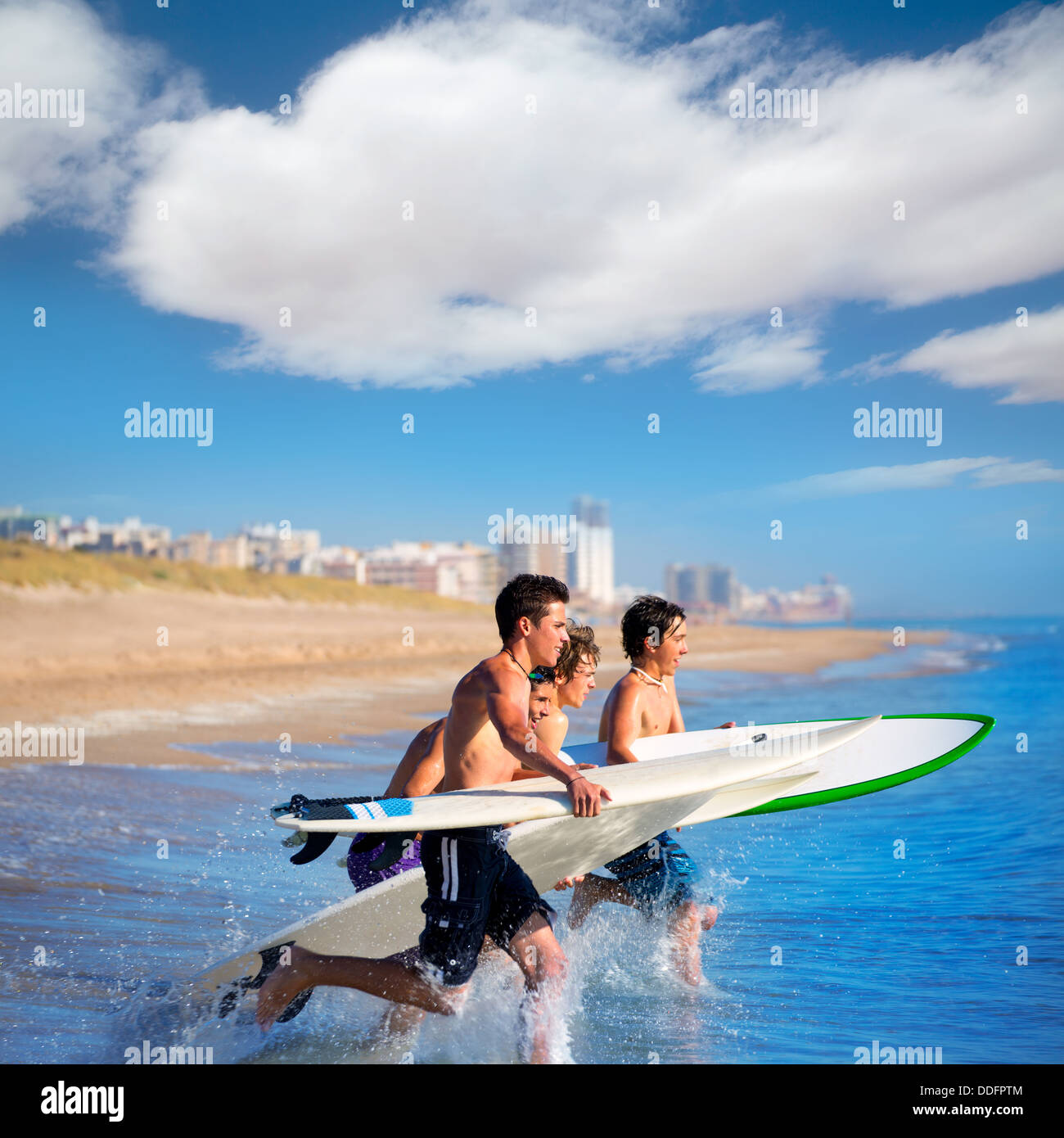 Teenager surfers surfing running jumping on surfboards at El Perello ...