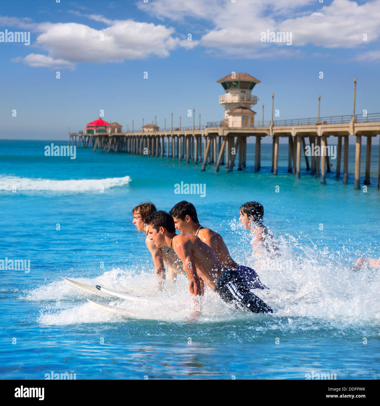 Teenager surfers surfing running jumping on surfboards at Huntington ...