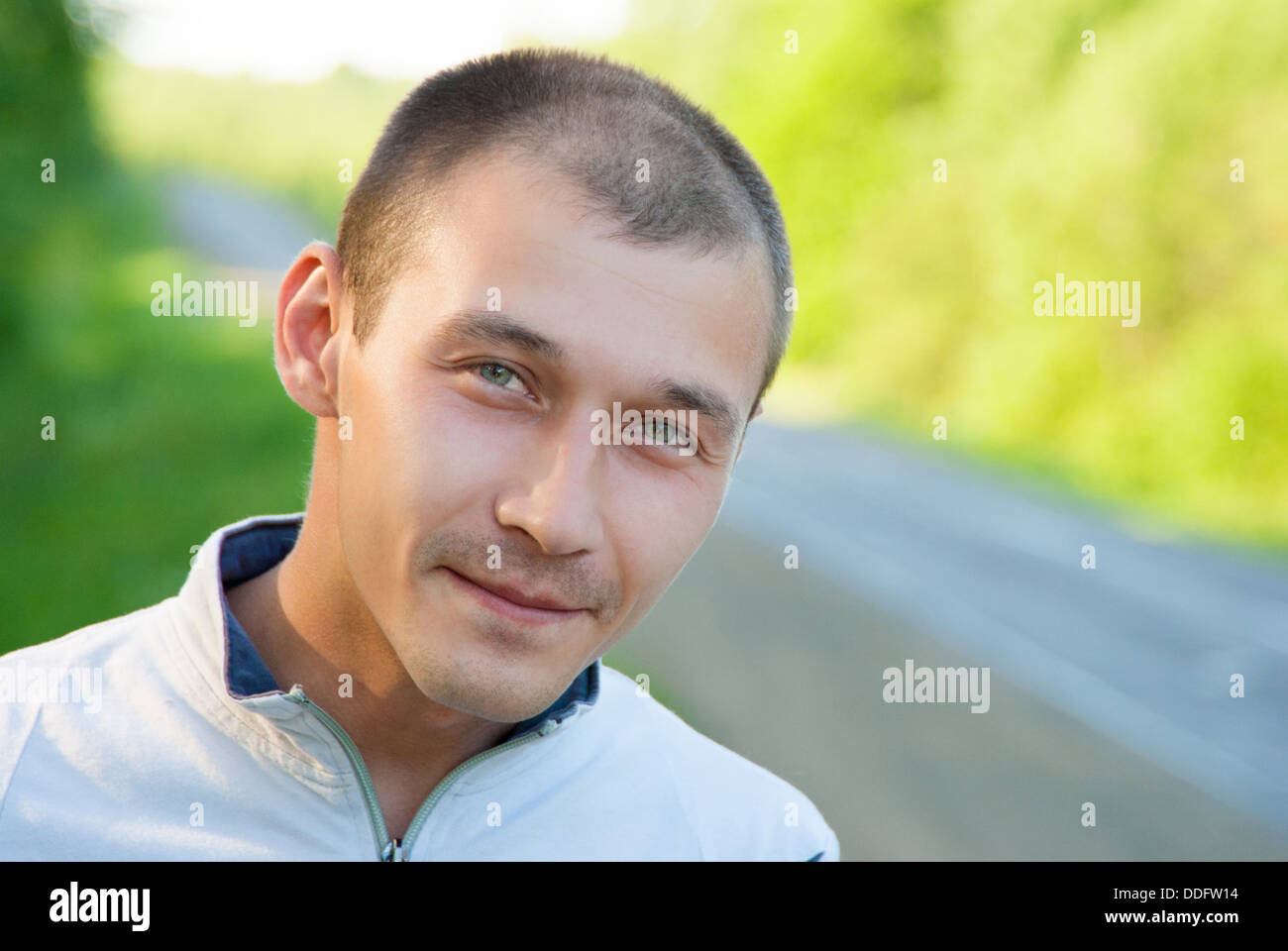 The young man with kind eyes on a summer background Stock Photo - Alamy